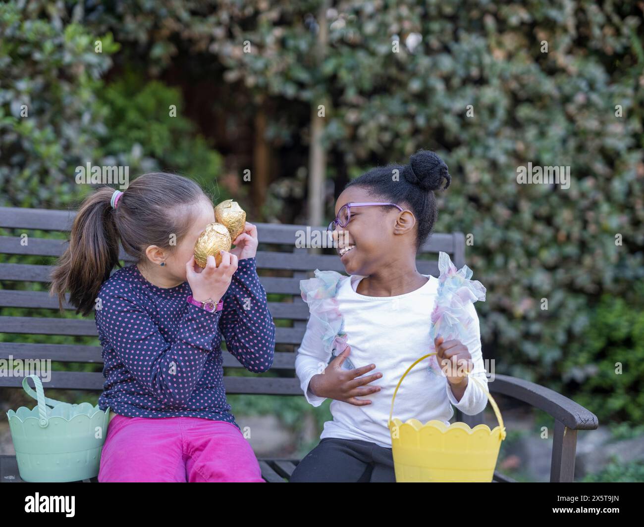 Girl friends (6-7) with baskets on Easter egg hunt Stock Photo - Alamy