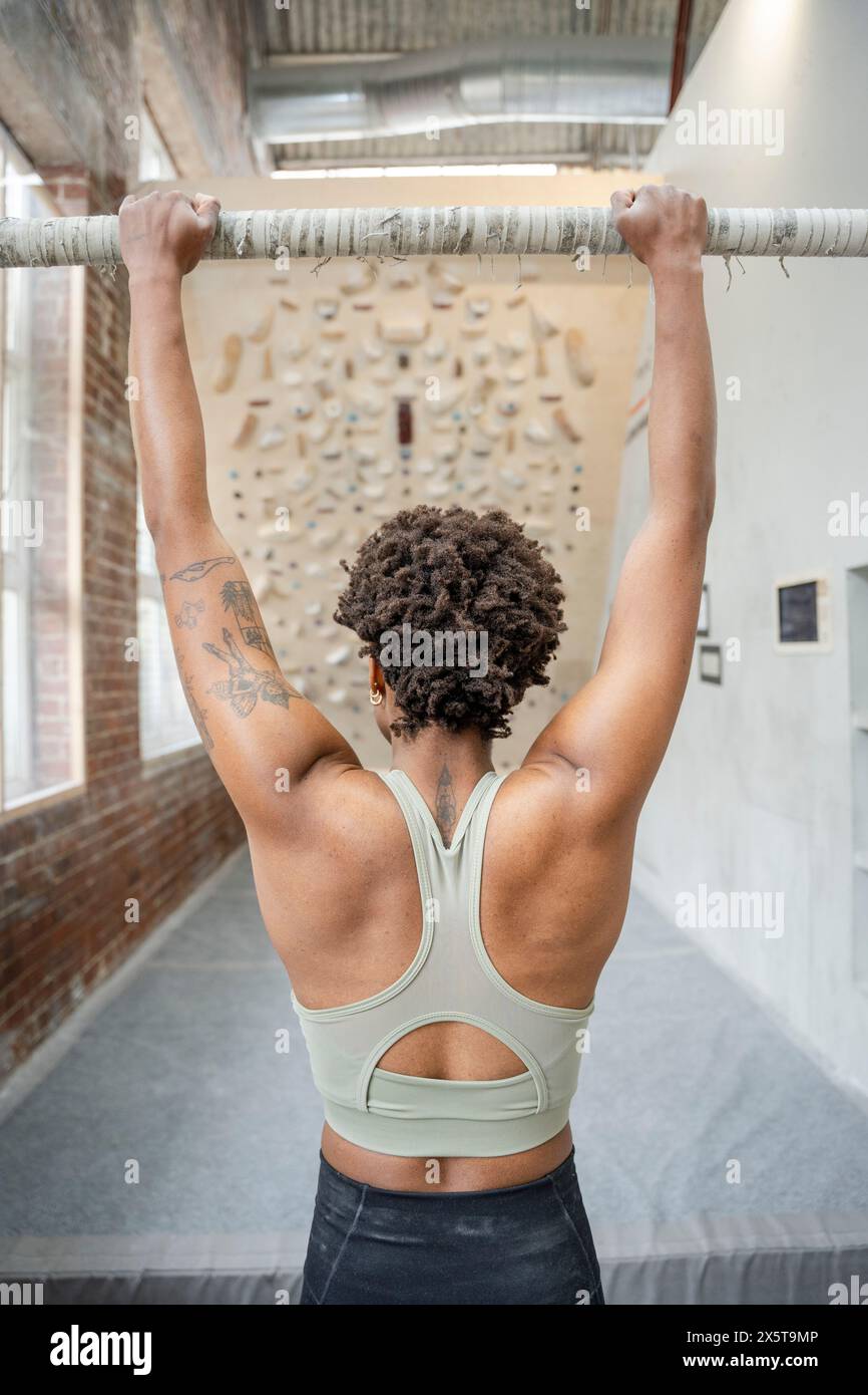 Woman performing chin-up exercise next to climbing wall Stock Photo - Alamy
