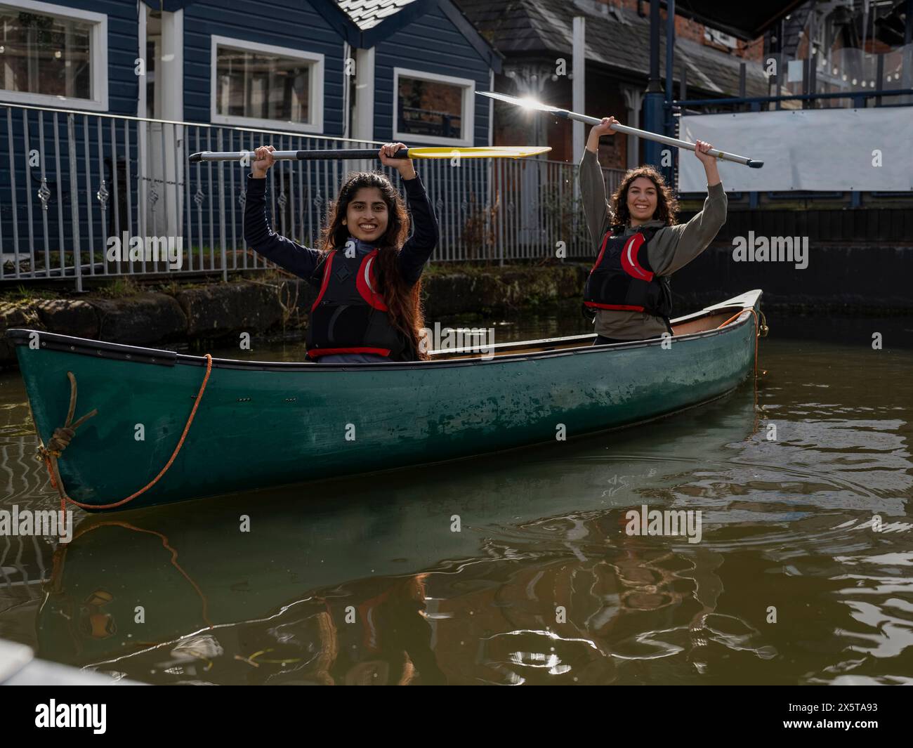 Two young women sitting in canoe Stock Photo - Alamy