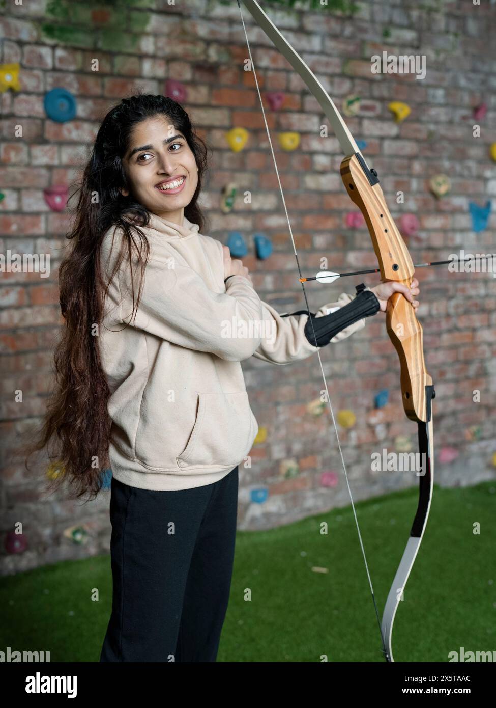 Young woman holding bow arrow hi-res stock photography and images - Alamy