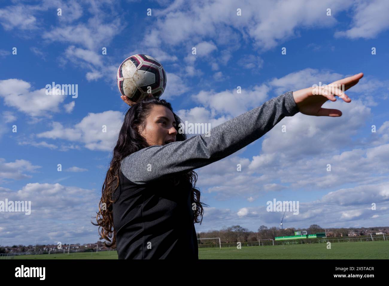 Young woman throwing soccer ball Stock Photo - Alamy