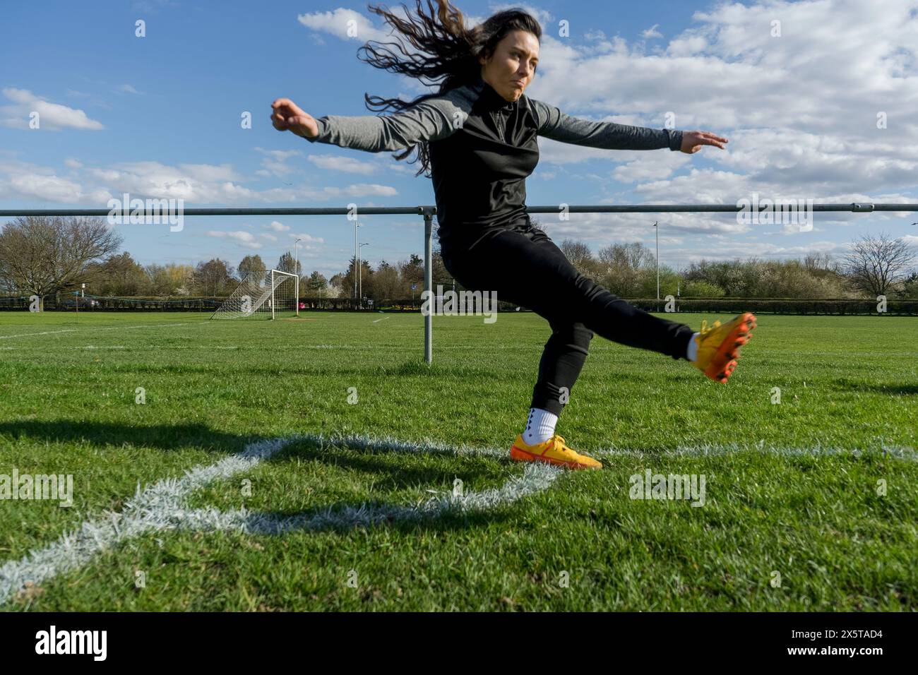 Young woman taking corner kick Stock Photo - Alamy