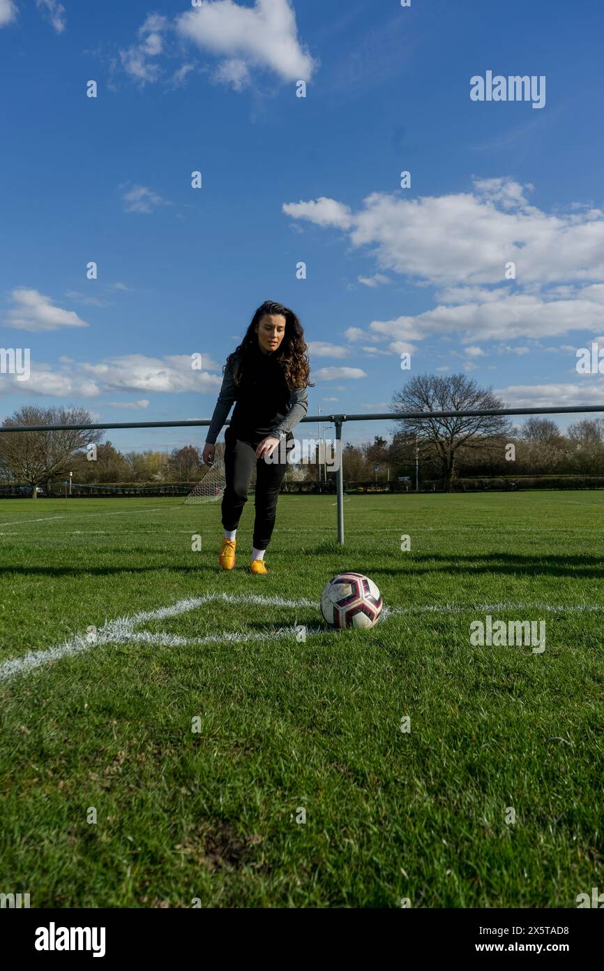 Young woman taking corner kick Stock Photo - Alamy