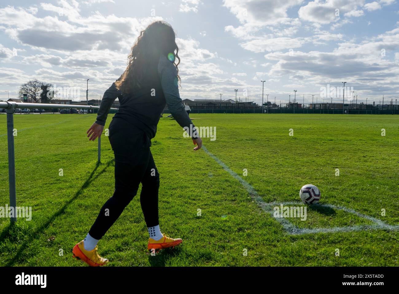 Young woman taking corner kick Stock Photo - Alamy