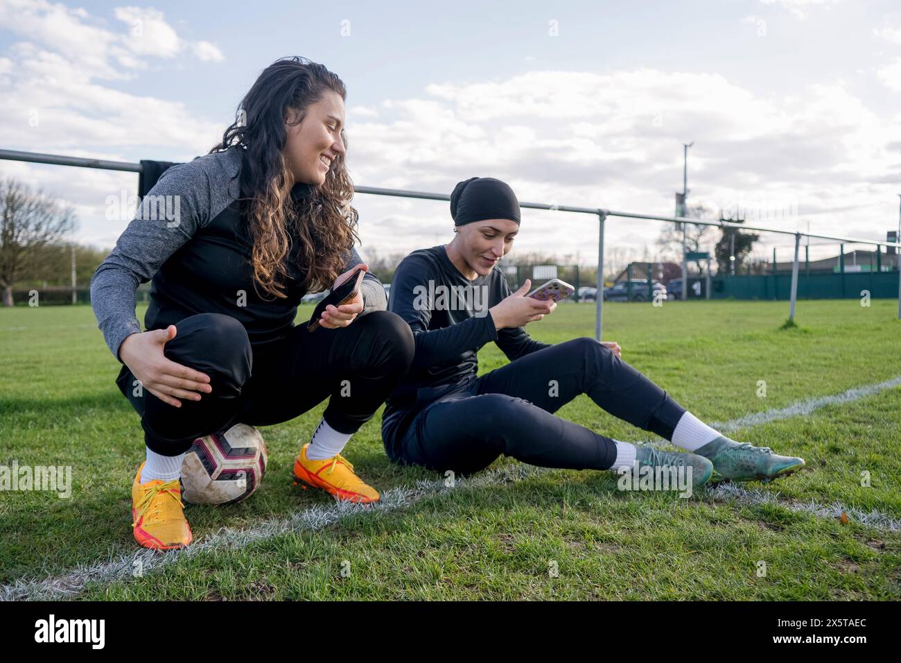 Female soccer players using phones during break Stock Photo - Alamy