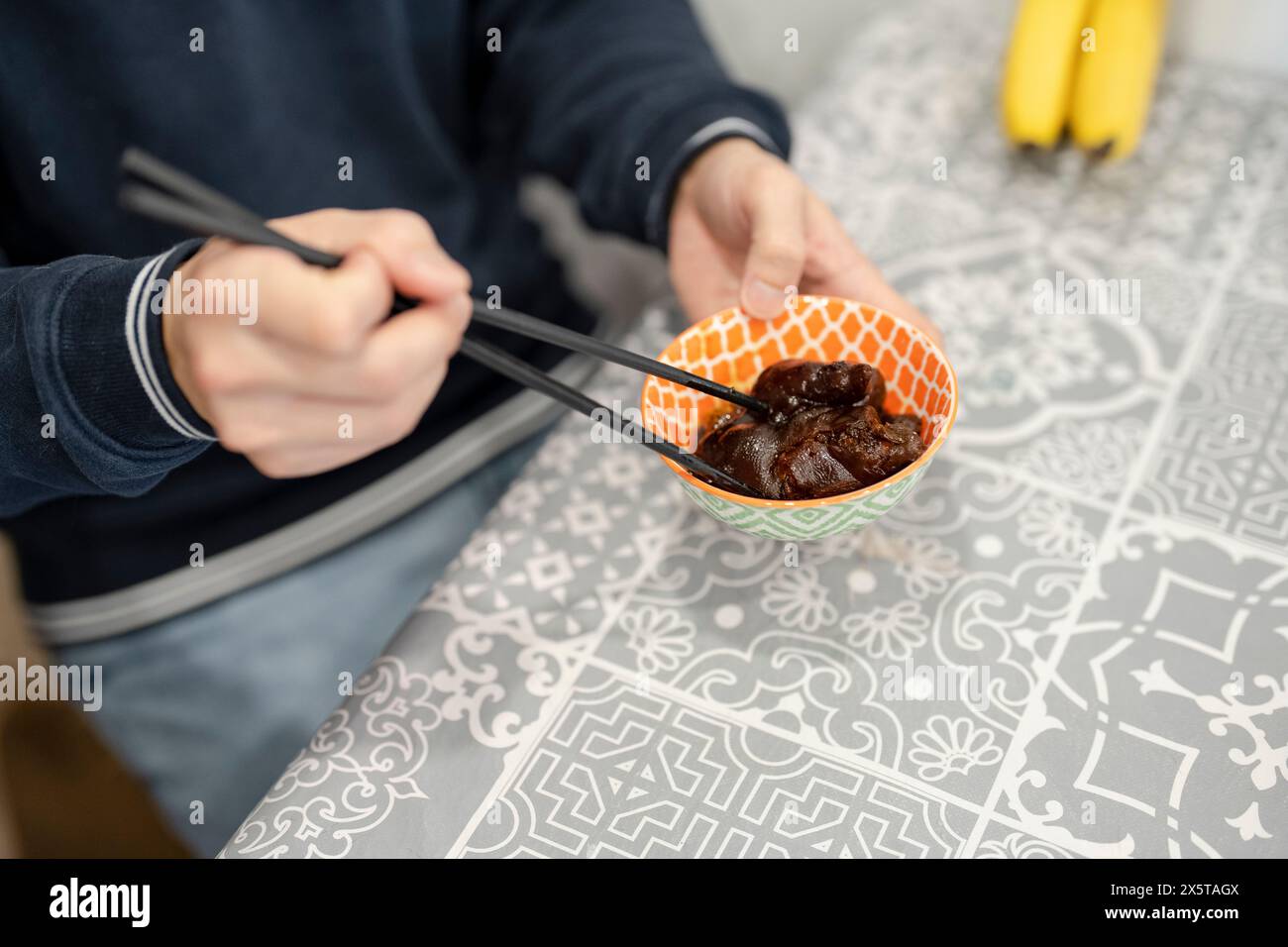 Man eating pork knuckle with ginger vinegar at home Stock Photo - Alamy