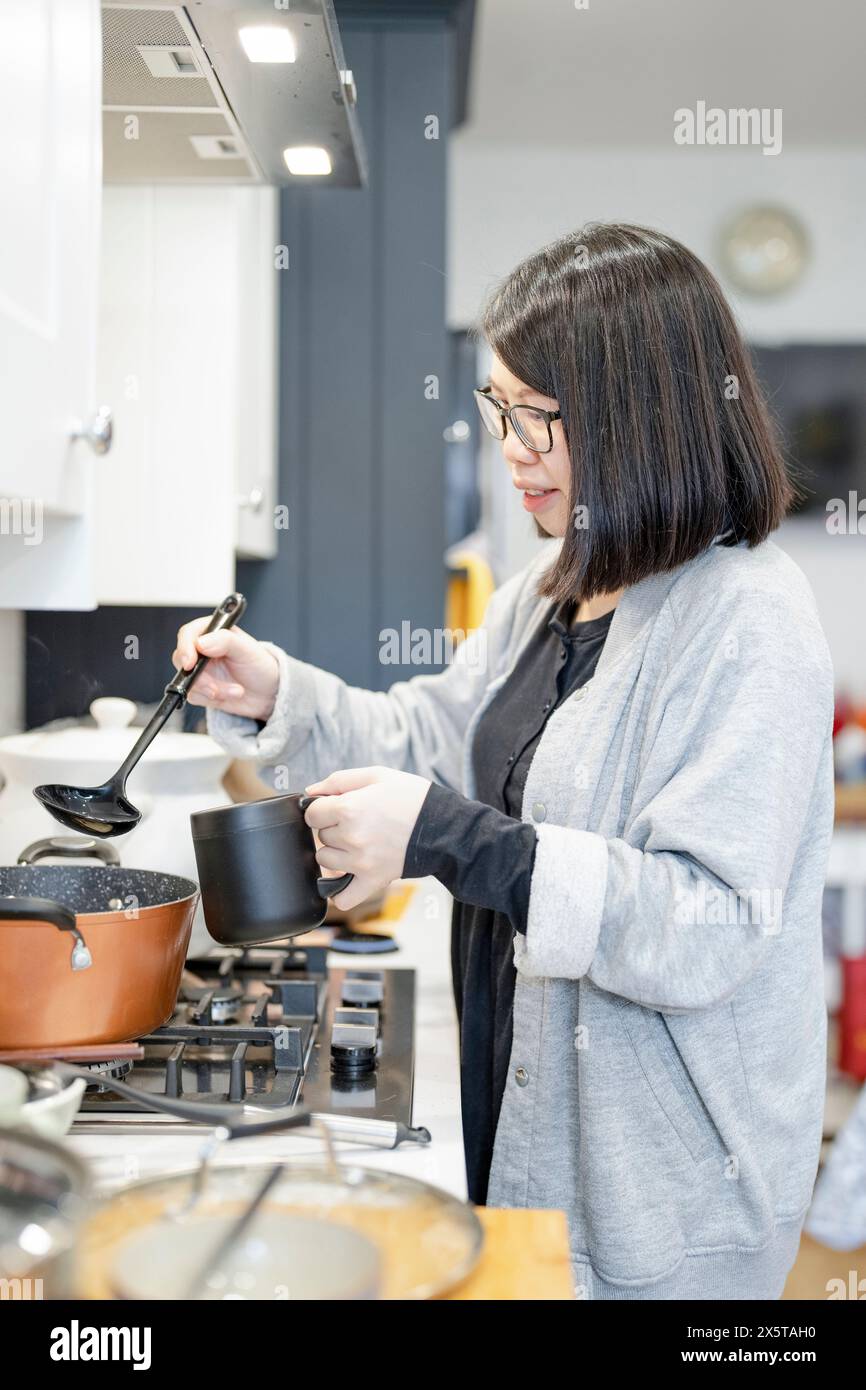 Woman pouring tea in kitchen Stock Photo - Alamy
