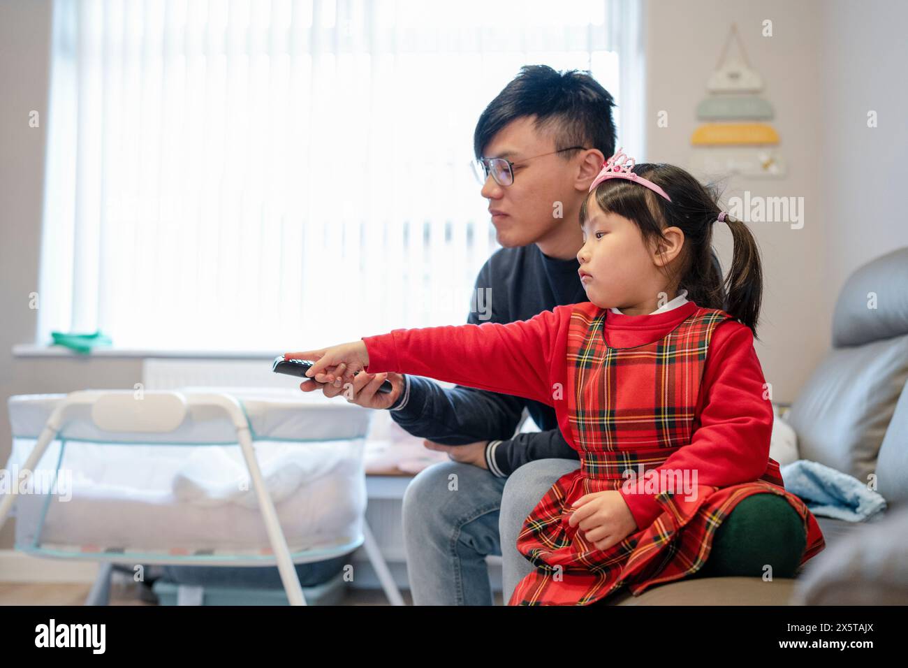 Father and daughter (4-5) using remote control together Stock Photo - Alamy