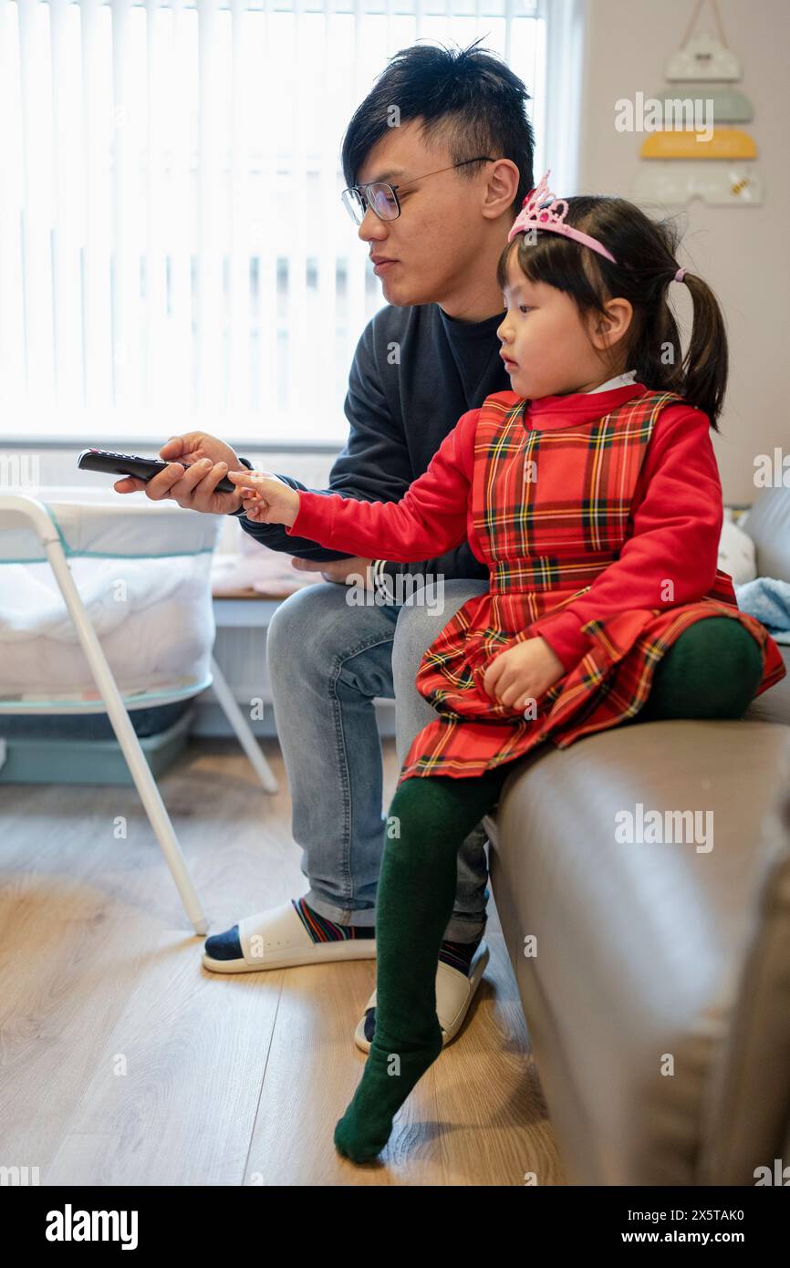 Father and daughter (4-5) using remote control together Stock Photo - Alamy