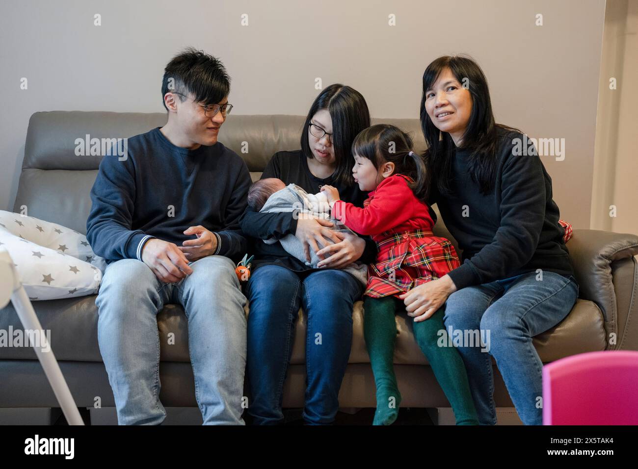 Two generation family with two children (0-1 months), (4-5) sitting on ...