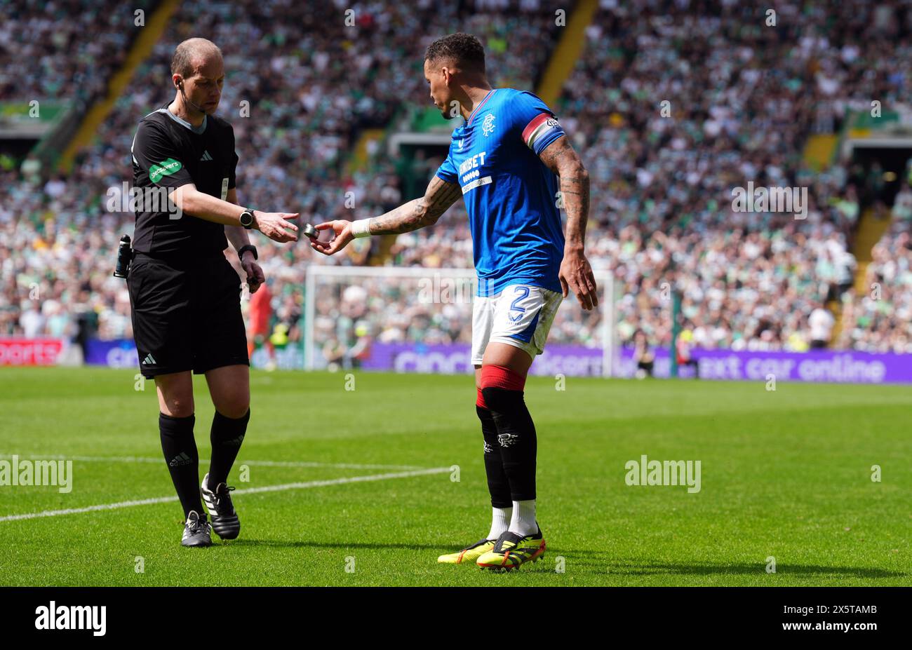 Rangers' James Tavernier passes an object thrown from the stands to referee William Collum ...