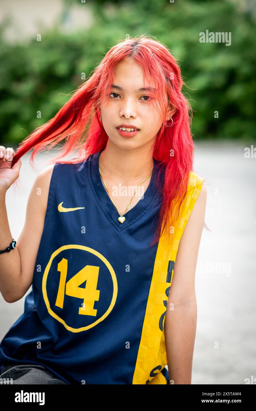 A beautiful young Filipino girl with red hair poses outside her home in ...