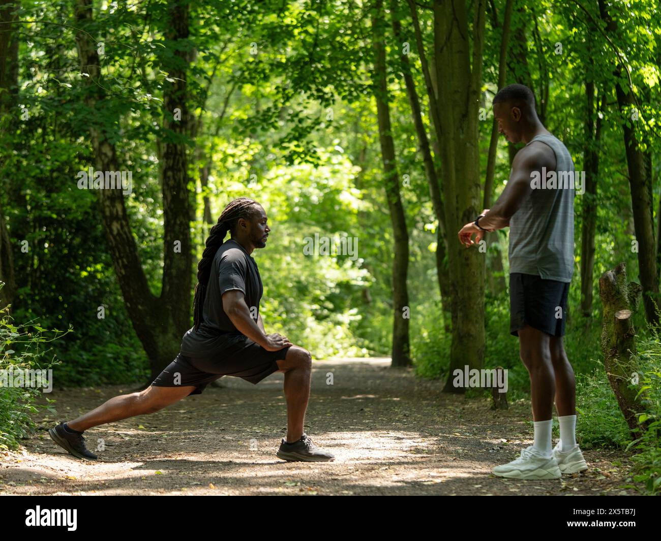 Two men stretching in forest Stock Photo - Alamy