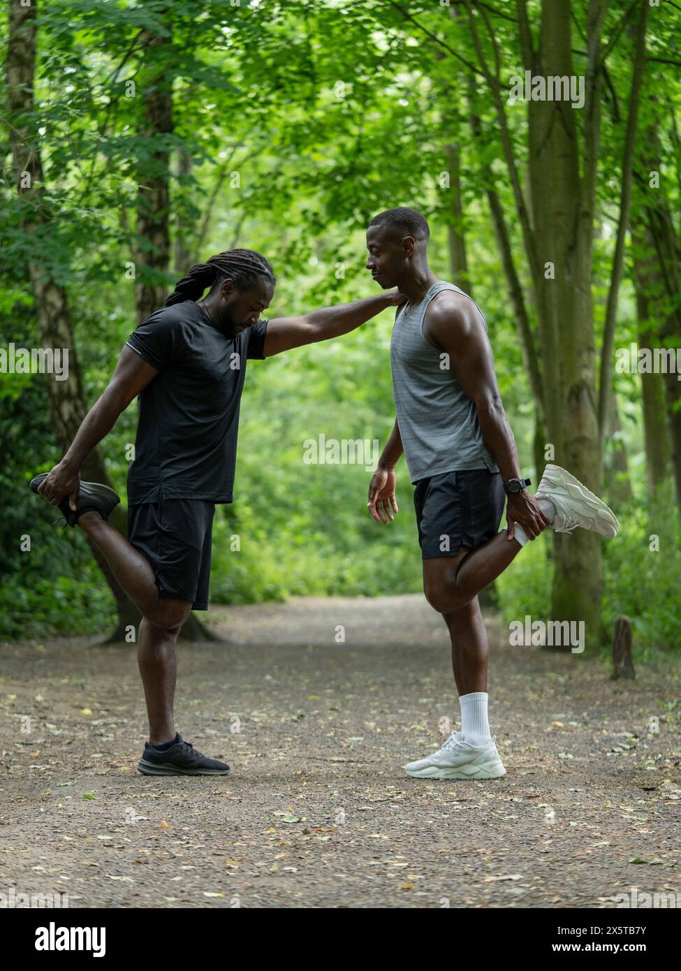 Two men stretching in forest Stock Photo - Alamy