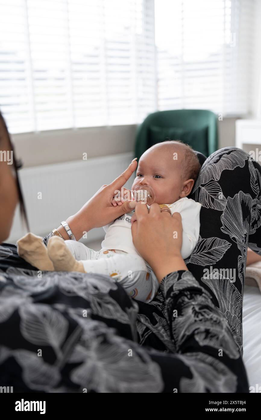 Woman giving pacifier to newborn baby girl at home Stock Photo - Alamy