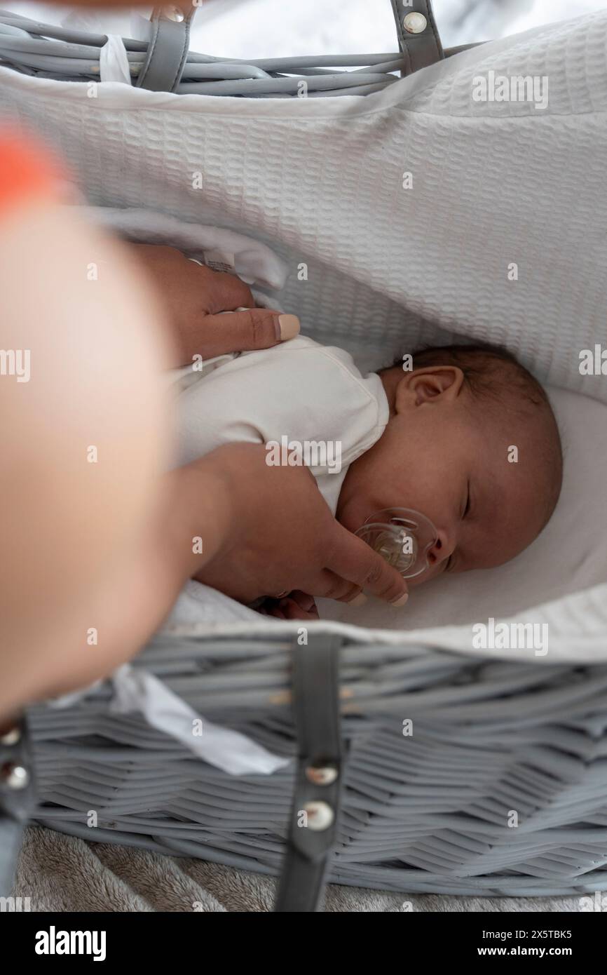 Mother putting to sleep newborn baby girl in crib Stock Photo - Alamy
