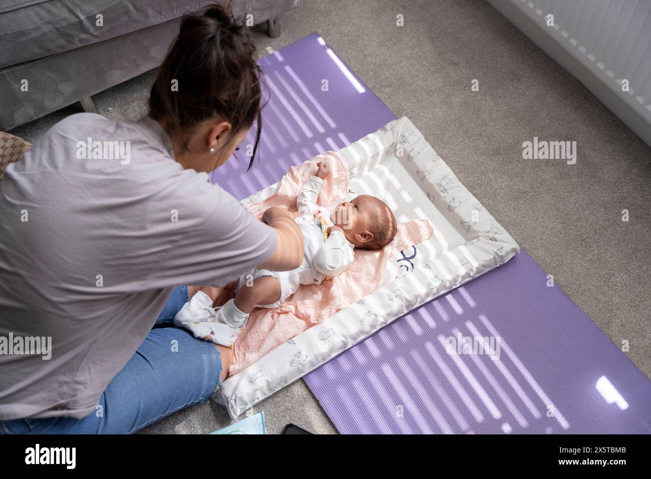 Mother changing diaper to newborn baby girl at home Stock Photo - Alamy