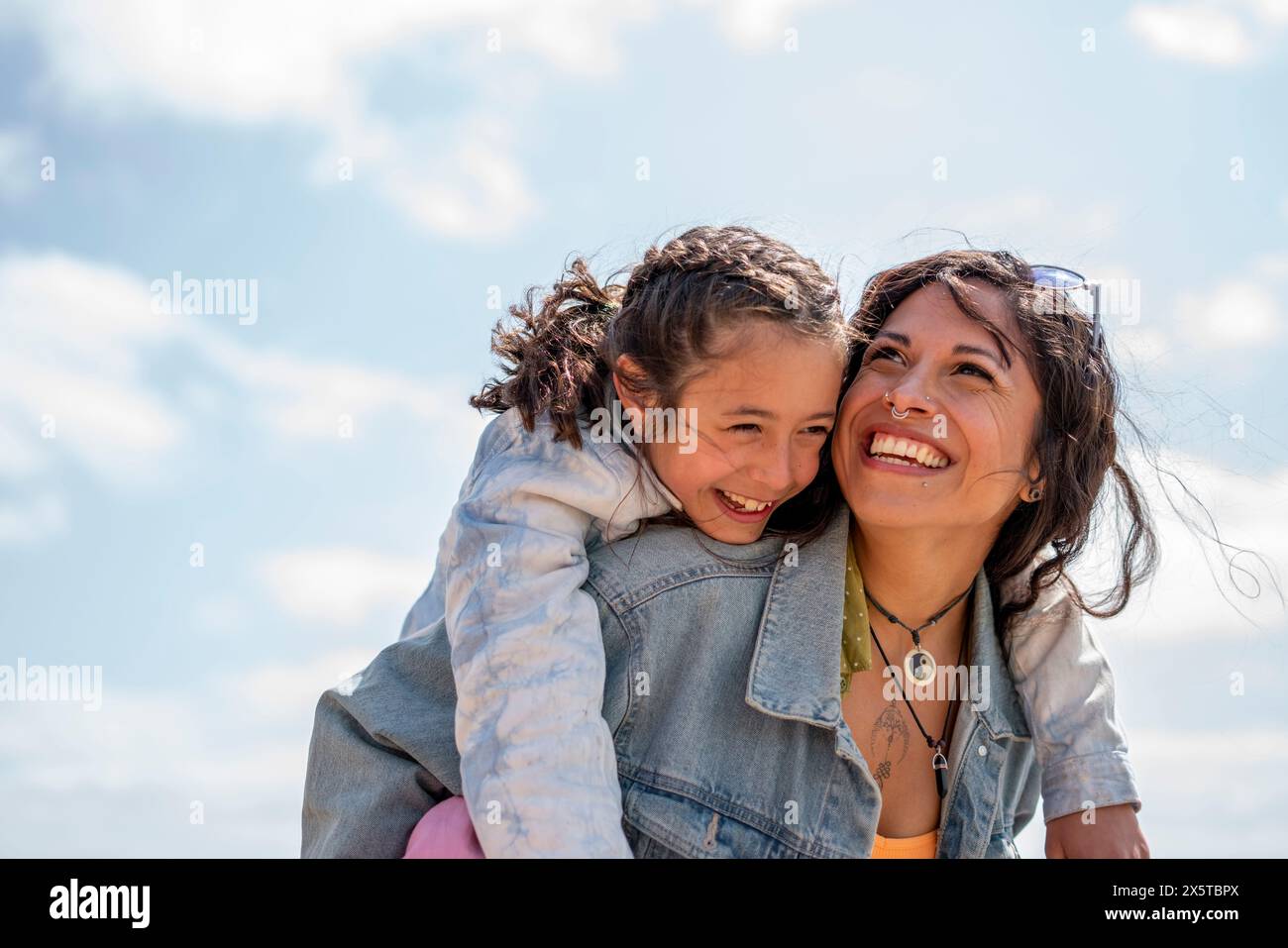 Smiling mother giving daughter (8-9) piggyback ride Stock Photo - Alamy