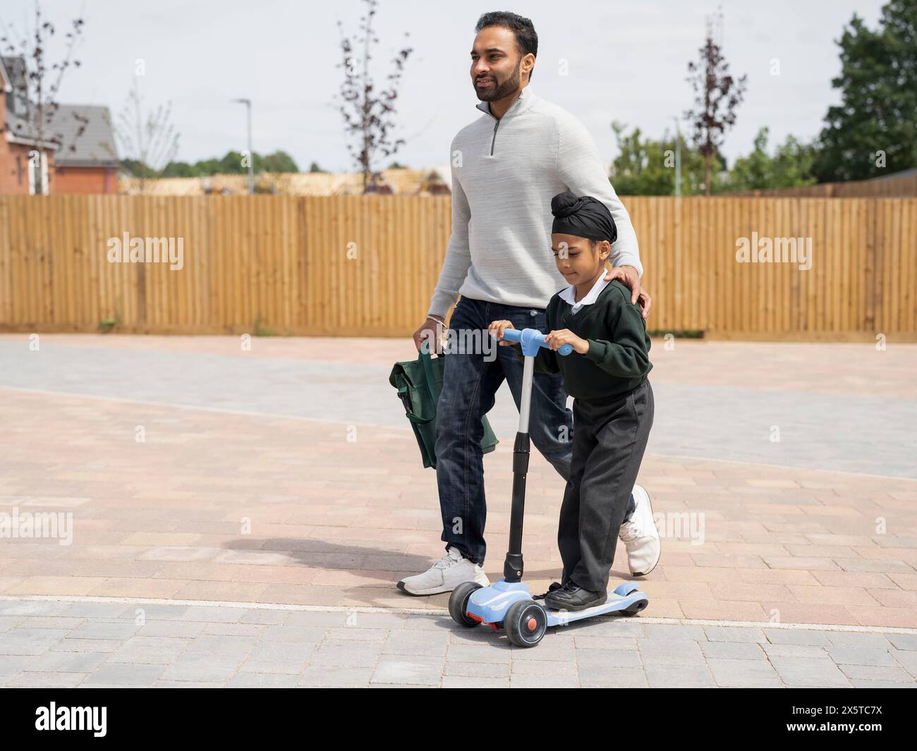 Boy (6-7) on push scooter walking with father to school Stock Photo - Alamy