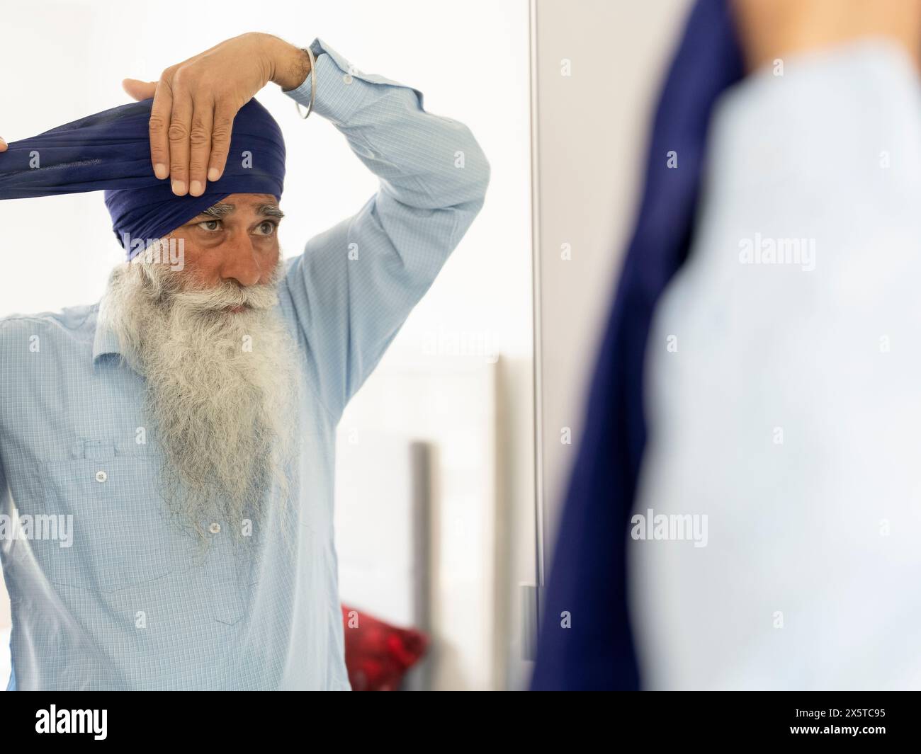 Senior man wrapping turban around head Stock Photo - Alamy