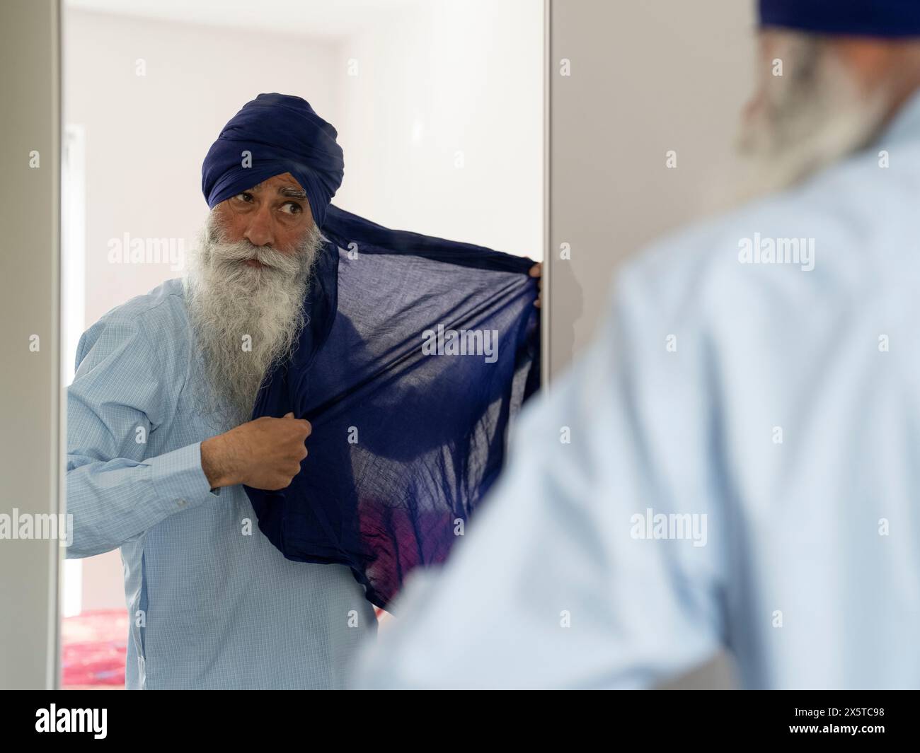 Senior man wrapping turban around head Stock Photo - Alamy