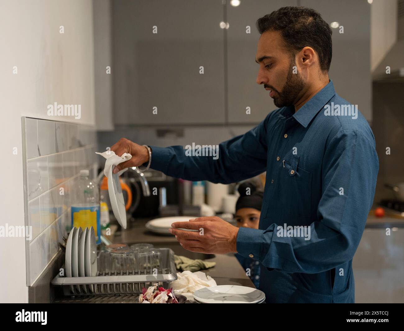 Man in traditional clothing washing plates Stock Photo - Alamy
