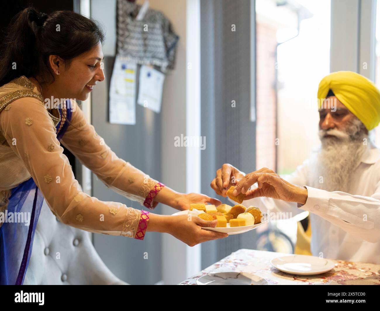 Family in traditional clothing sharing food Stock Photo - Alamy