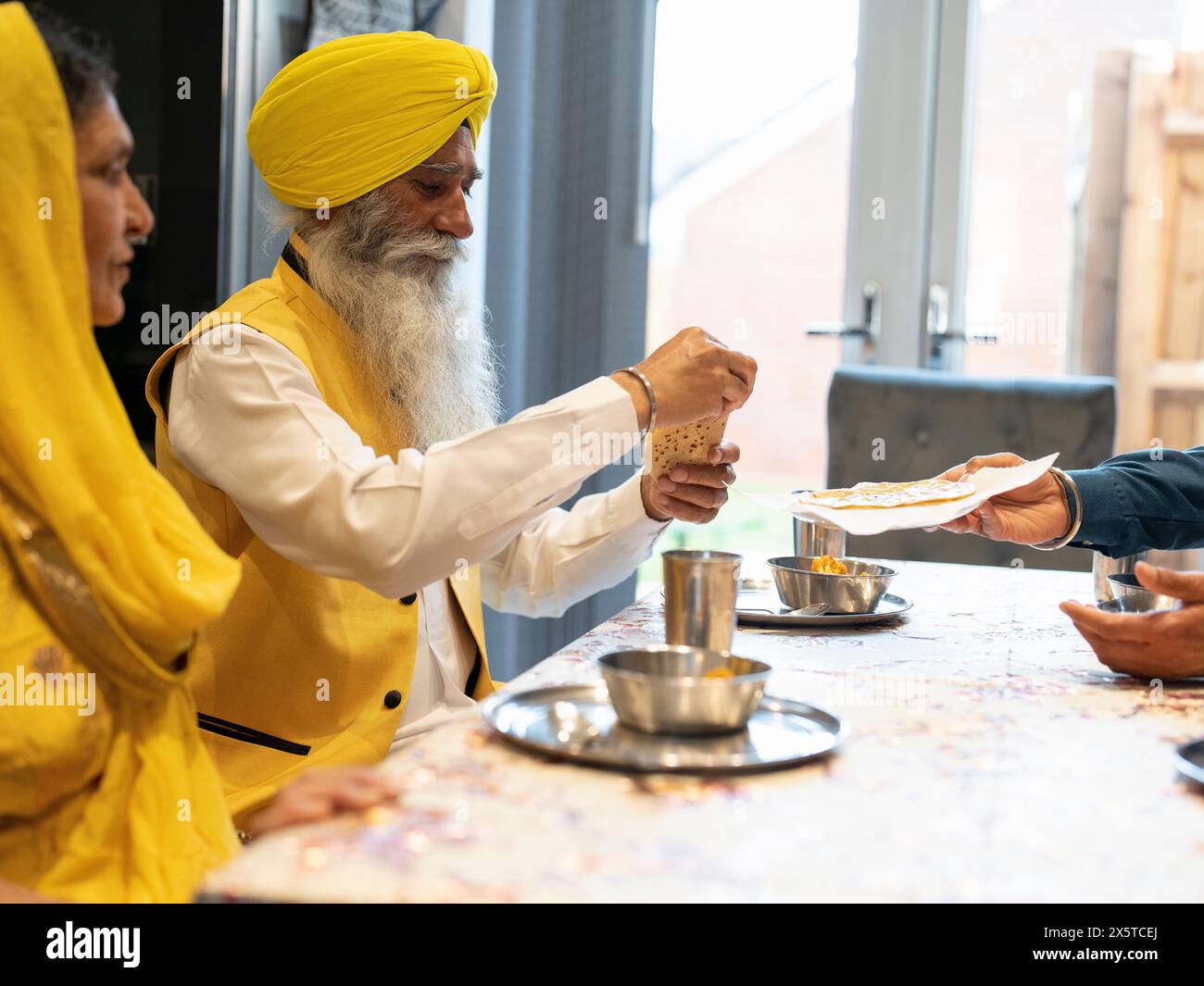Family in traditional clothing eating meal at home Stock Photo - Alamy
