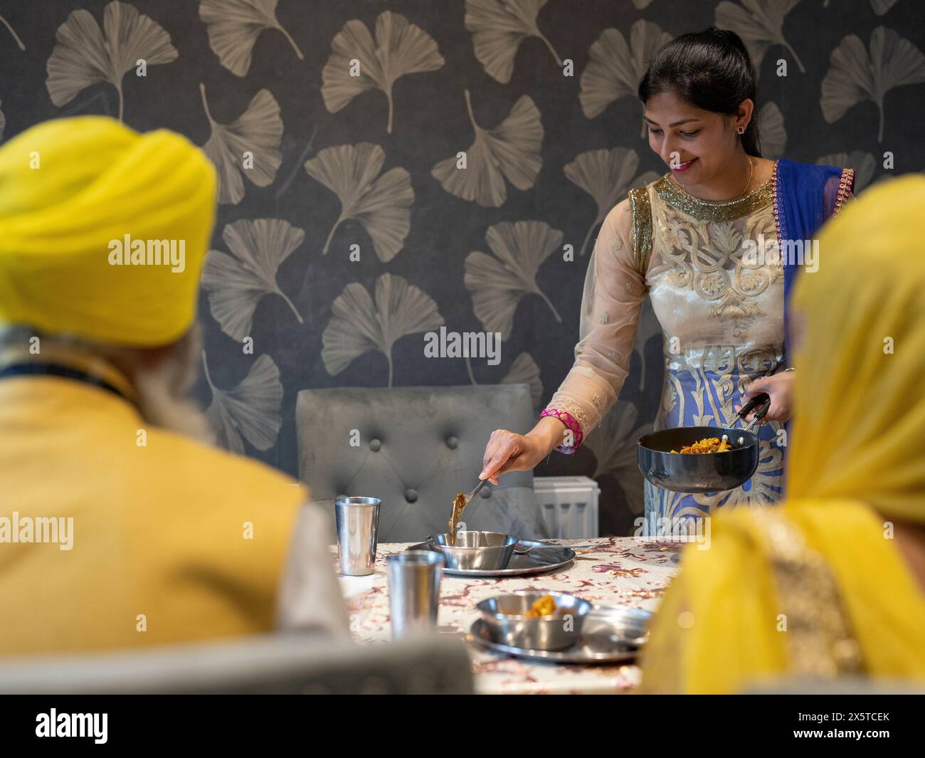 Family in traditional clothing eating meal at home Stock Photo - Alamy