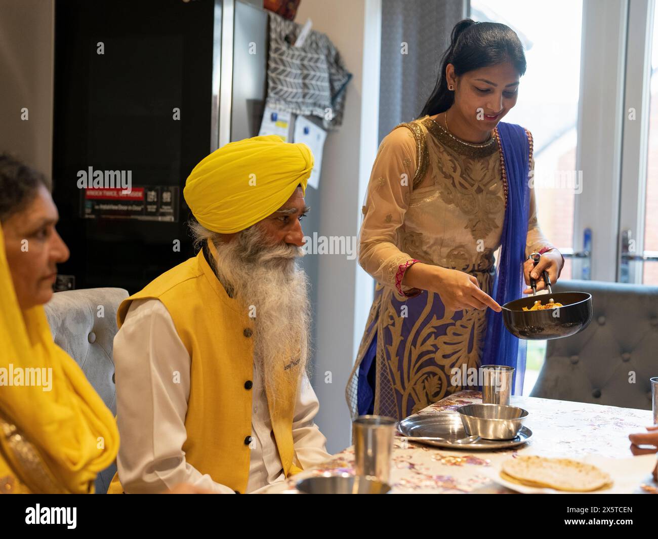 Family in traditional clothing eating meal at home Stock Photo - Alamy
