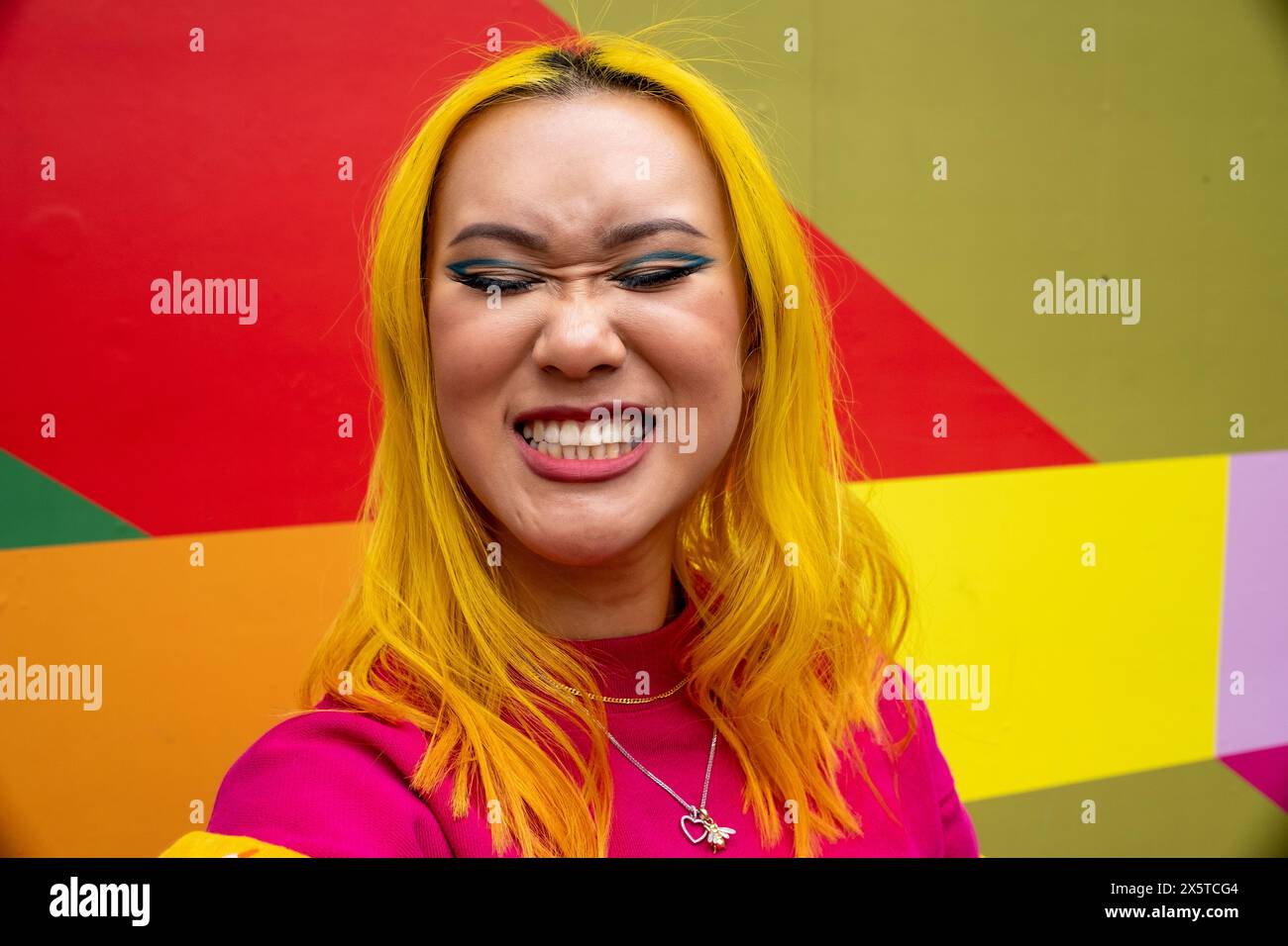 Smiling young woman with yellow hair showing teeth Stock Photo - Alamy