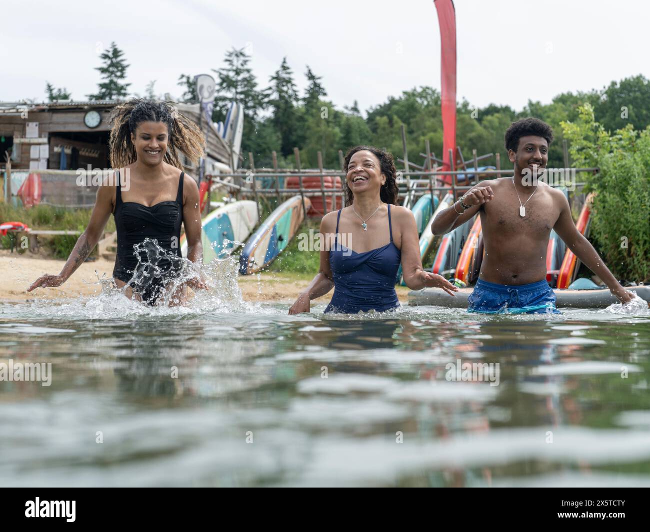Friends walking into lake Stock Photo - Alamy
