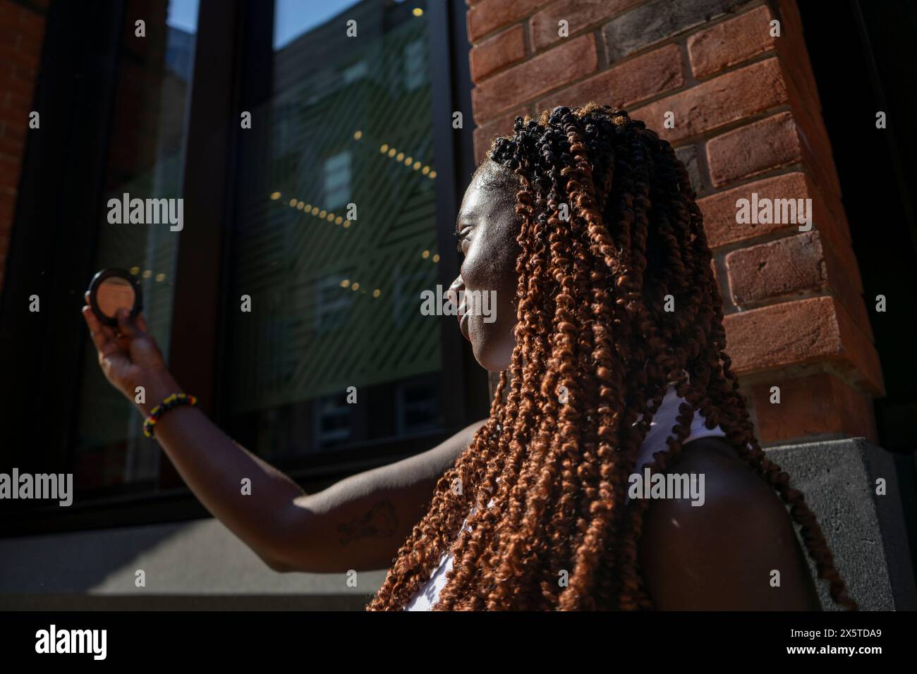 Woman looking at small mirror Stock Photo - Alamy