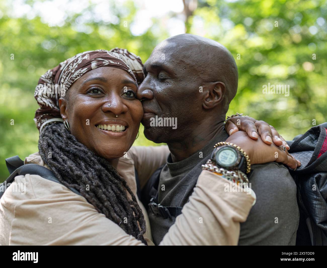 Smiling hiking couple hugging in forest Stock Photo - Alamy