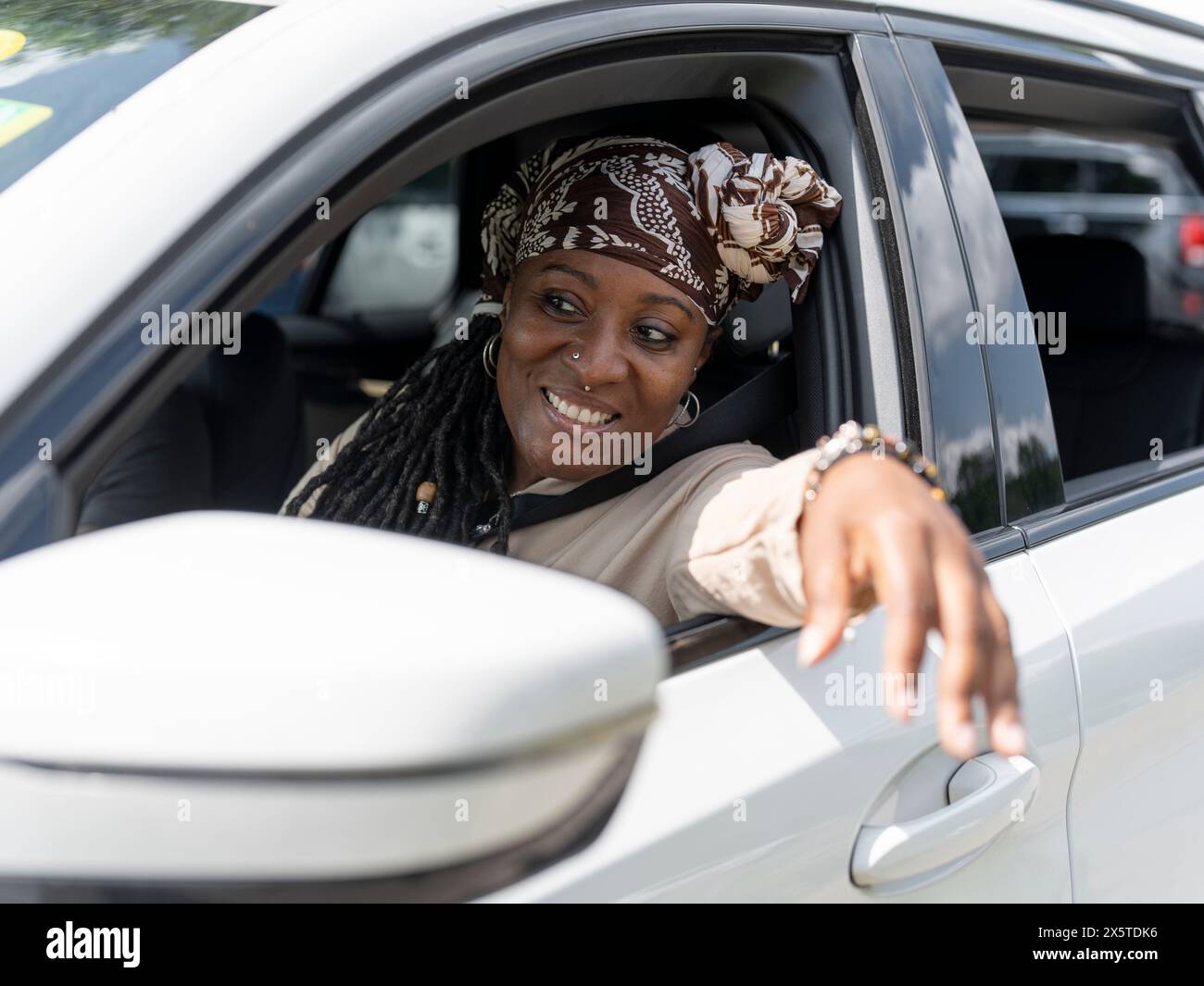 Woman sticking arm through car window Stock Photo - Alamy