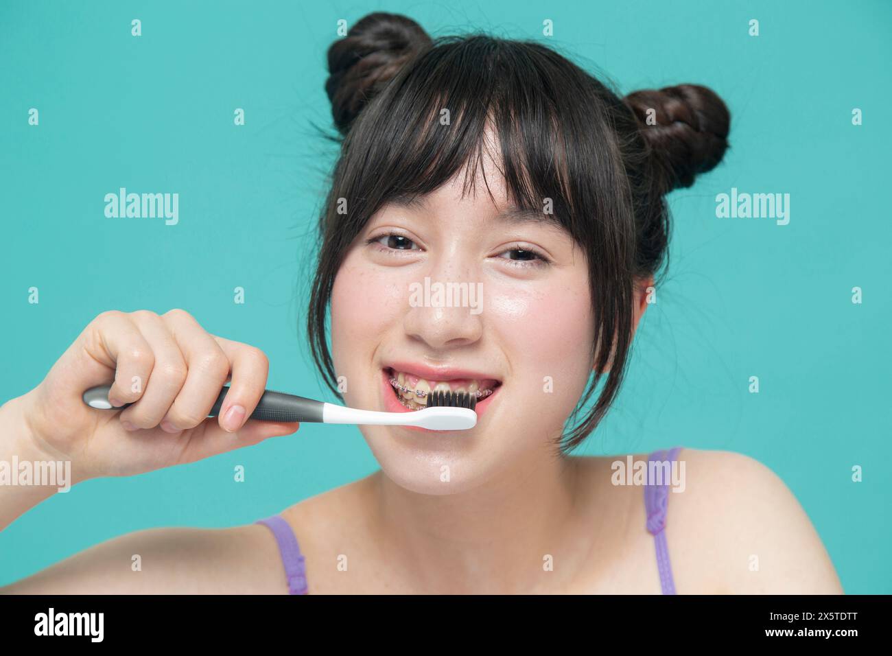 Studio portrait of girl brushing teeth Stock Photo - Alamy