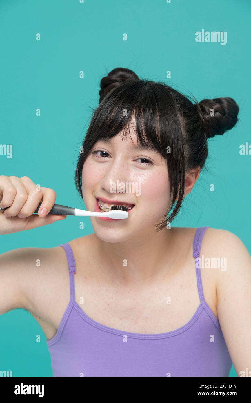 Studio portrait of girl brushing teeth Stock Photo - Alamy