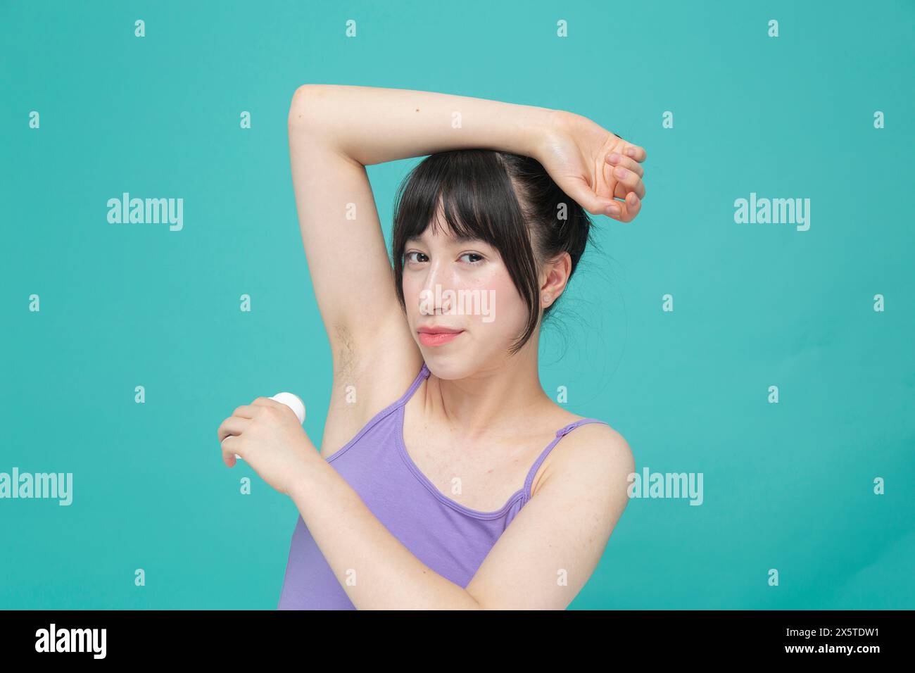 Studio portrait of girl using deodorant Stock Photo - Alamy