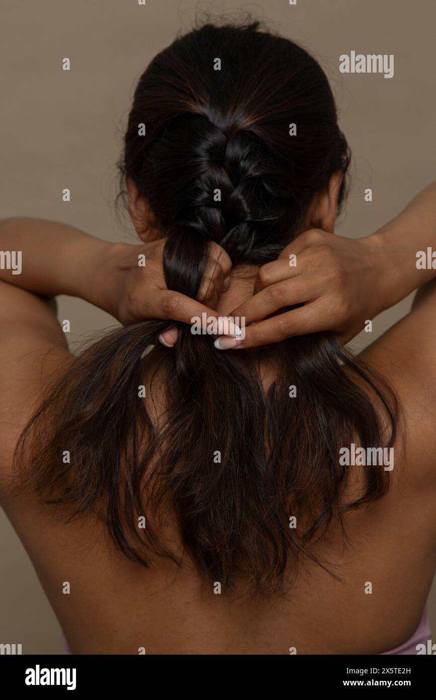 Rear view of woman braiding hair Stock Photo - Alamy