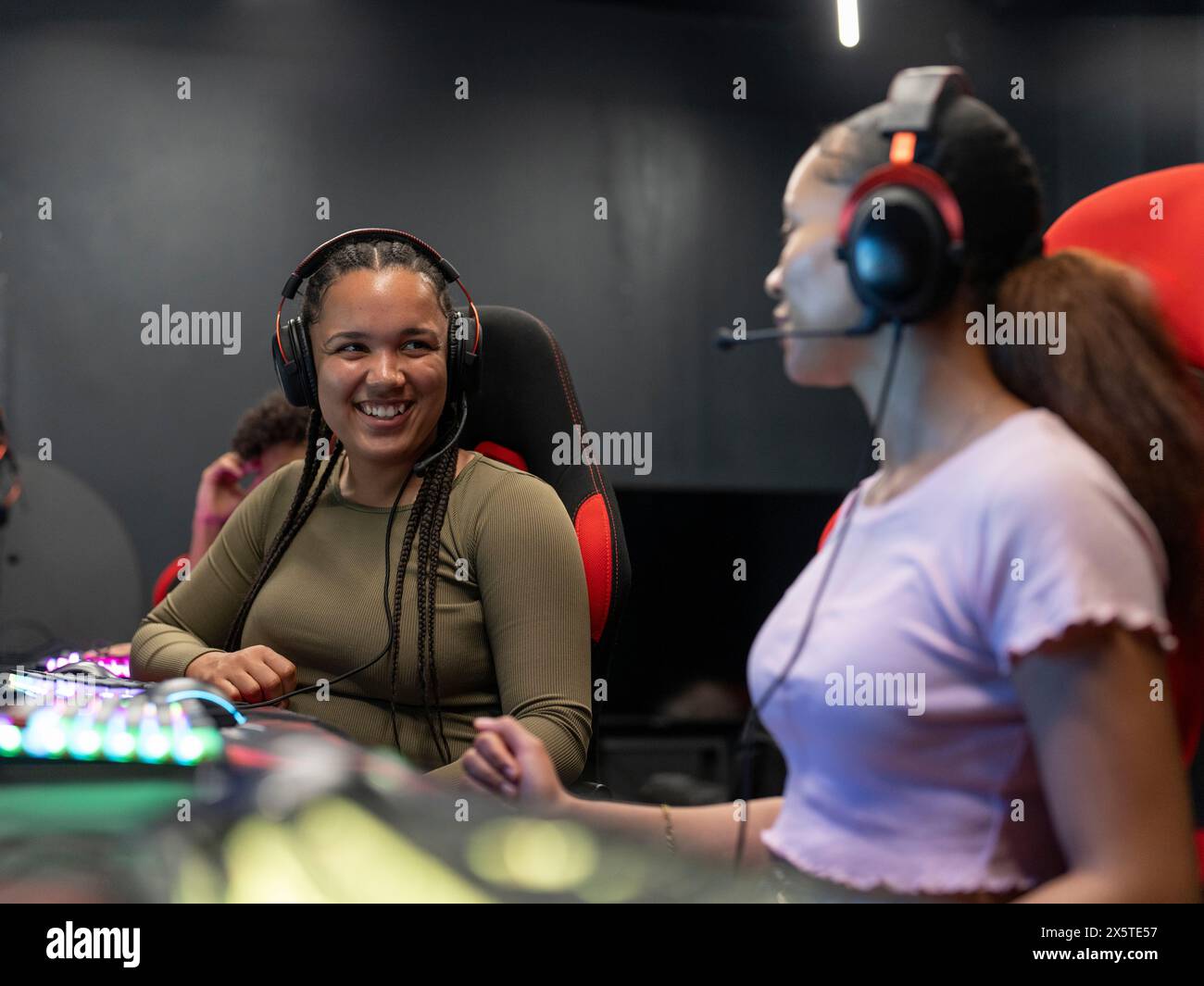 Female friends playing video games in gaming club Stock Photo - Alamy