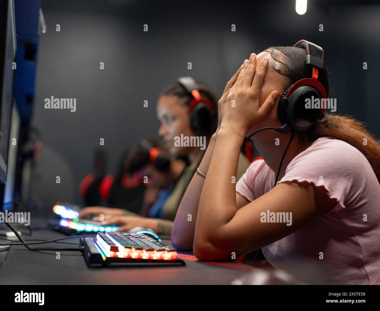 Female friends playing video games in gaming club Stock Photo - Alamy