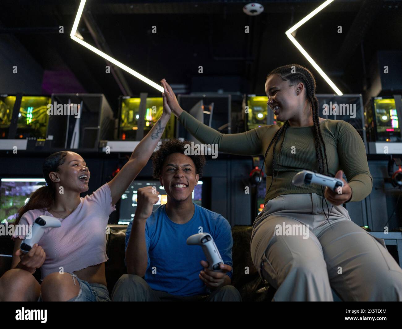 Excited friends playing video games in gaming club Stock Photo - Alamy