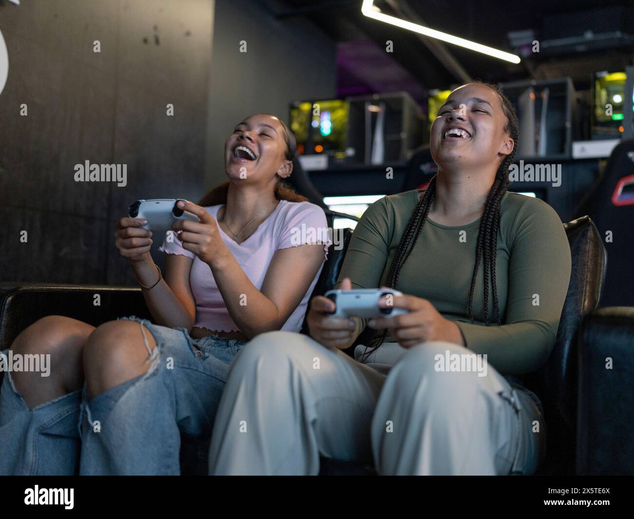 Female friends playing video games in gaming club Stock Photo - Alamy