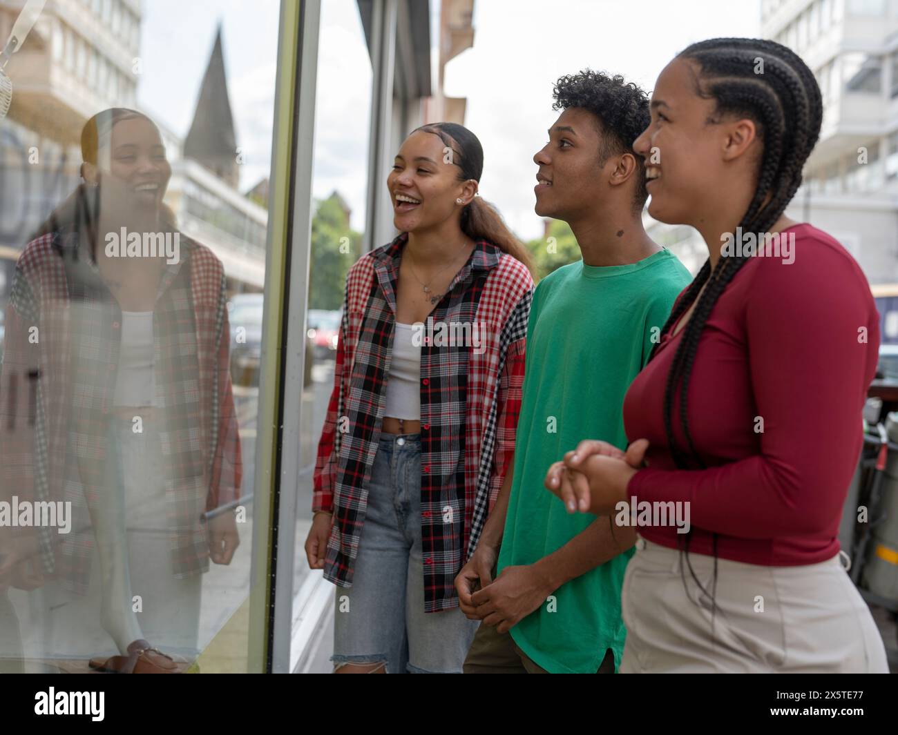 Friends looking at window display Stock Photo - Alamy