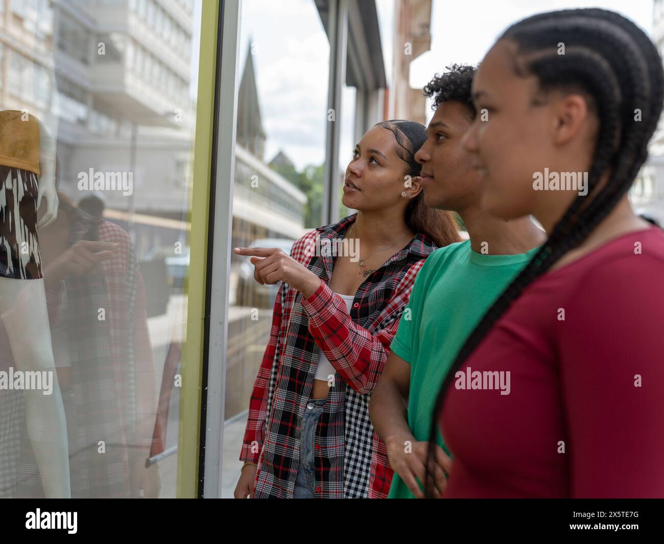 Friends looking at window display Stock Photo - Alamy