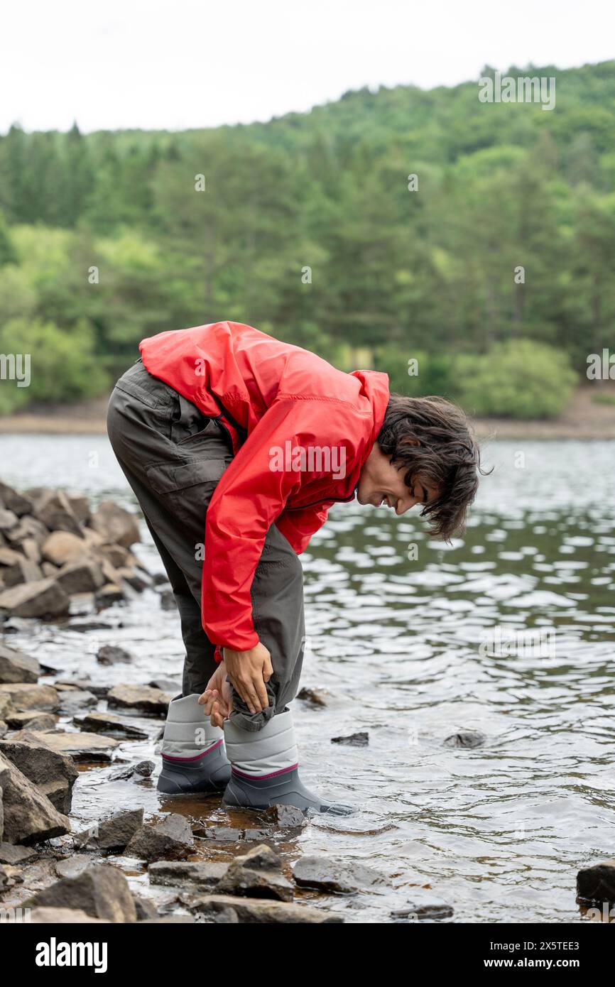 Young man wading in lake Stock Photo - Alamy