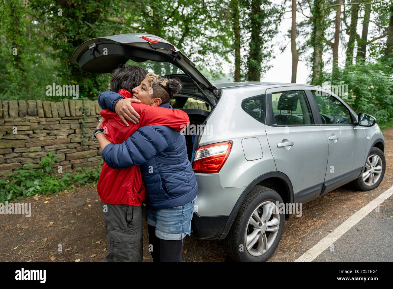 Mother and son hugging by car after hike Stock Photo - Alamy