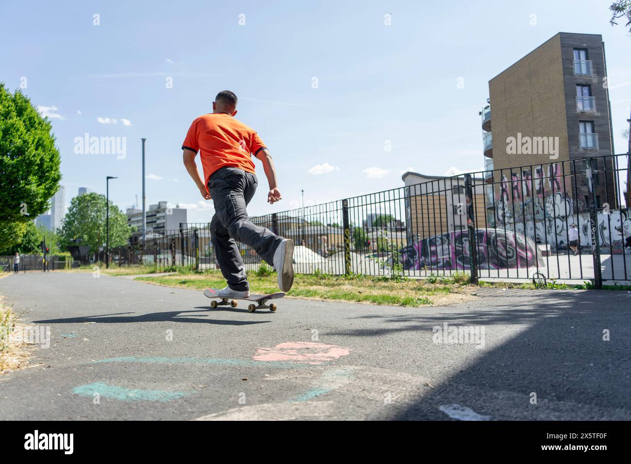 Rear view man skateboarding on hi-res stock photography and images - Alamy