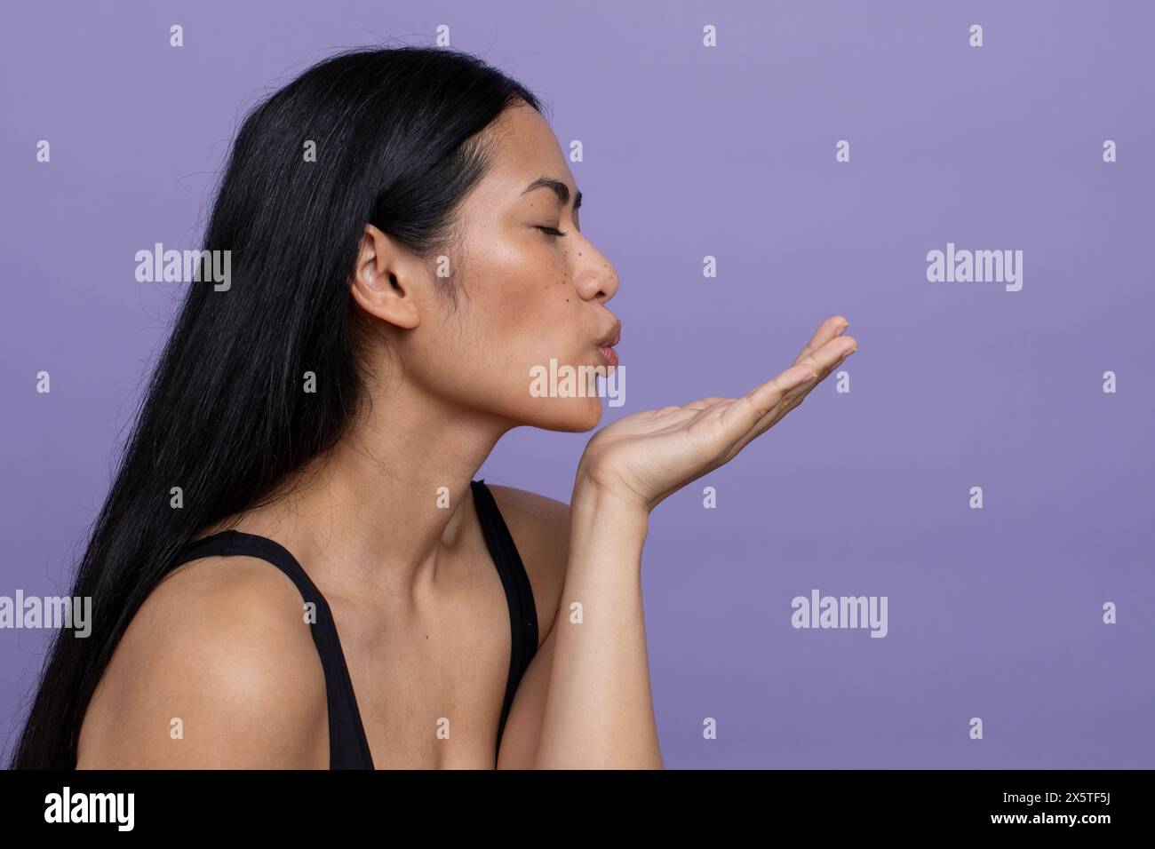 Side view of woman blowing kiss Stock Photo - Alamy