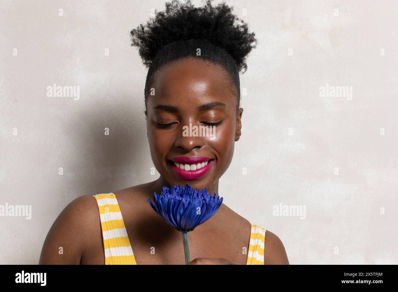 Portrait of smiling woman with holding blue flower Stock Photo - Alamy